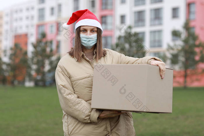 一个戴着红色圣诞老人帽和医疗保护面具的送图片-包图网企业站