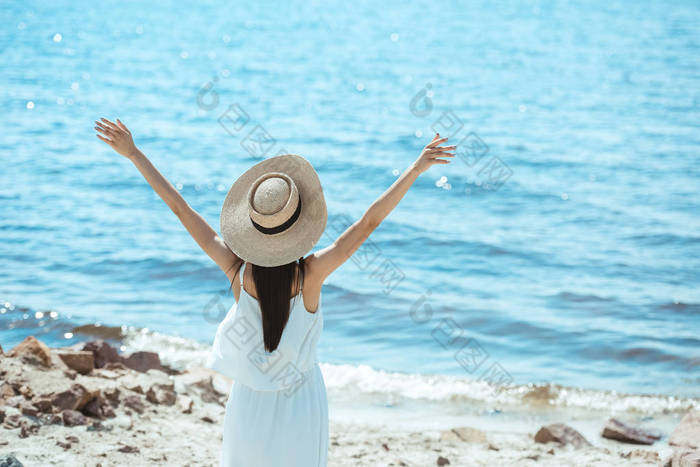 妇女的后方看法在草帽和白色礼服站立以宽广图片-包图网企业站