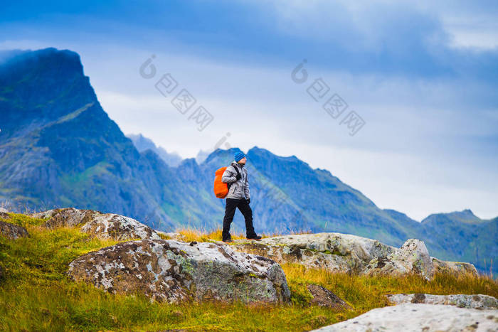 在挪威徒步旅行徒步者与红色背包站立在山的图片-包图网企业站