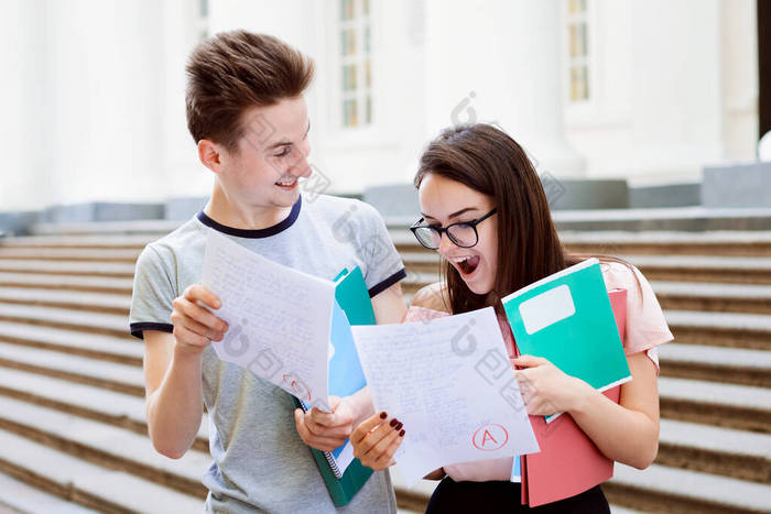 两个兴奋的学生在室外大楼的大楼梯附近取得图片-包图网企业站