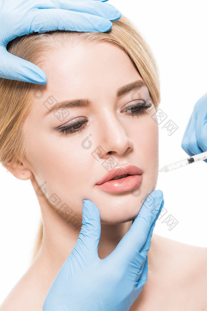 美容师手用手术刀靠近年轻女子的脸的特写 包图企业站