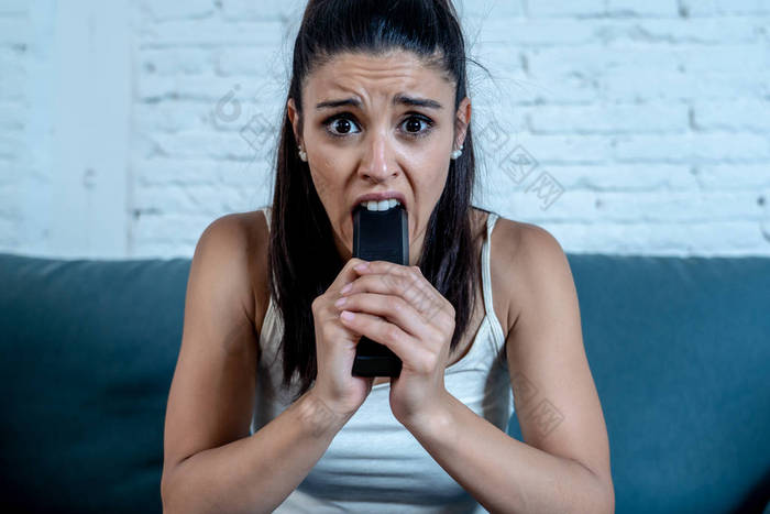 美丽的拉丁女人害怕害怕和厌恶而看电视恐怖 包图企业站