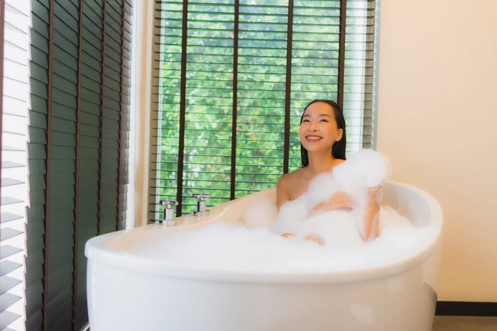 年轻快乐美丽的亚洲女人闭上眼睛微笑着牵着 包图企业站