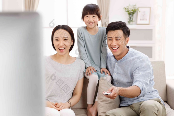 幸福的一家三口在客厅看电视 包图企业站
