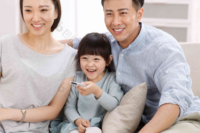 幸福的一家三口在客厅看电视 包图企业站