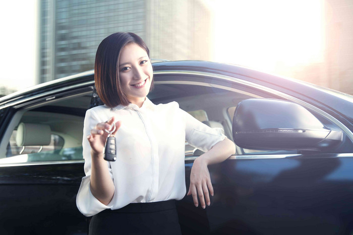 青年女人站在汽车旁边 包图企业站