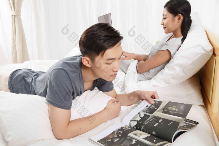 青年男人在床上看书图片 包图网企业站