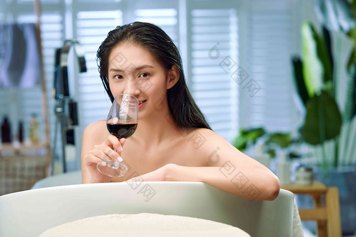 浴缸内漂亮的年轻女人和红酒 包图企业站