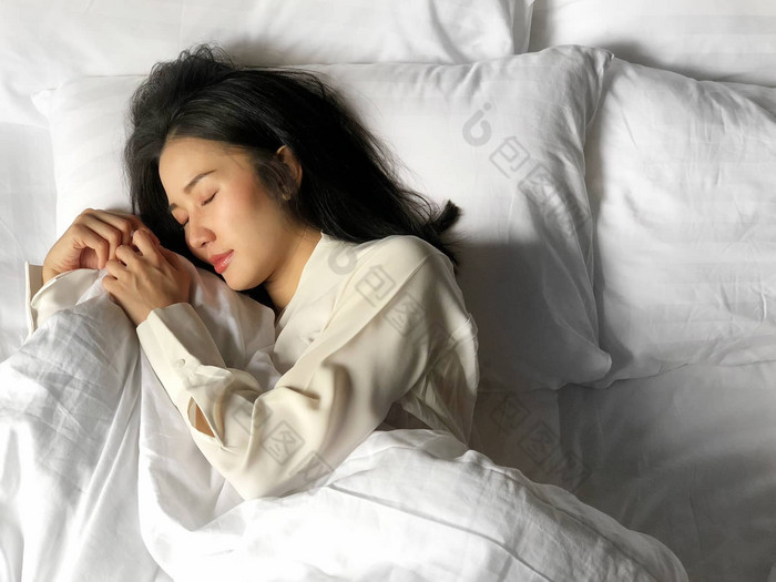 美丽的亚洲女人睡觉床上白色被子图片 包图网企业站