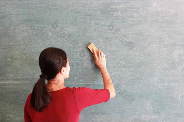 亚洲人教师擦掉向黑板和板橡皮擦采用公司图片-包图网企业站